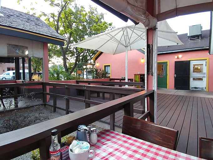 The outdoor seating area serves breakfast with a side of desert air&mdash;where checkered tablecloths meet wooden decks under Moab's endless sky.