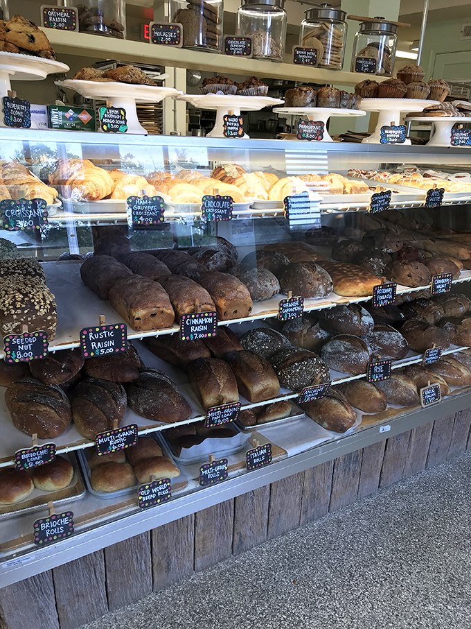 A display case that's essentially a museum of carbohydrate masterpieces. Each loaf tells a different story of fermentation and flavor.