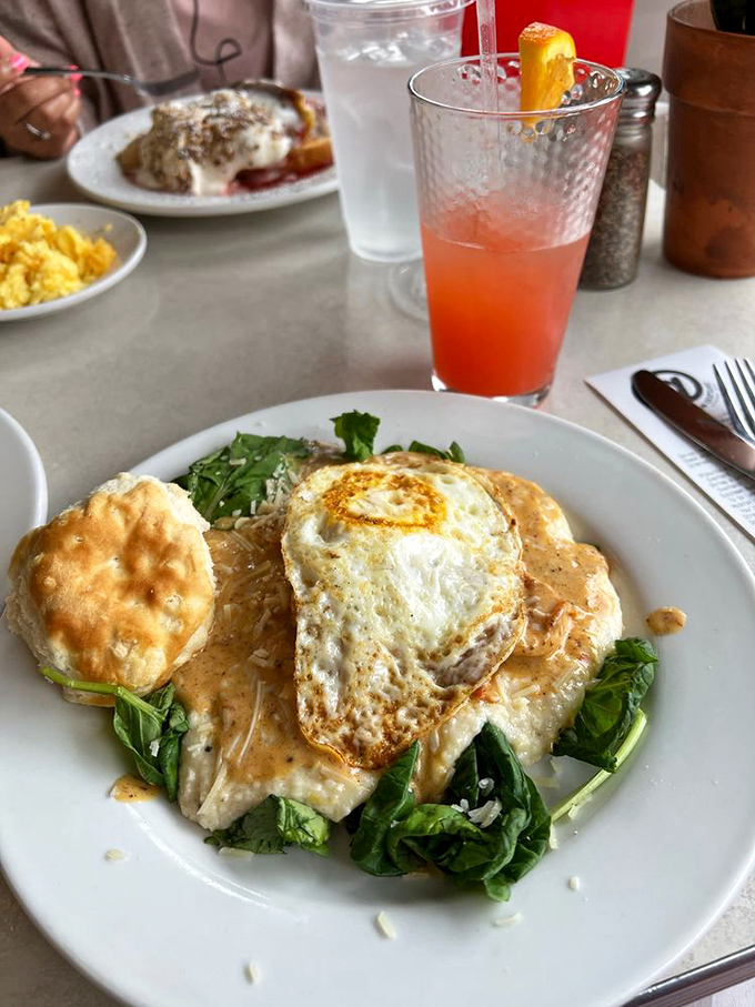 Shrimp and grits with a perfectly fried egg—the breakfast equivalent of hitting the jackpot. That biscuit on the side is just showing off.