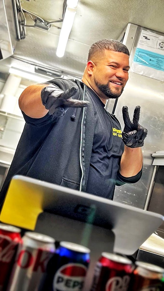 The peace sign says it all&mdash;this is a man who knows he's bringing happiness one smashed patty at a time. Burger artistry with a smile.