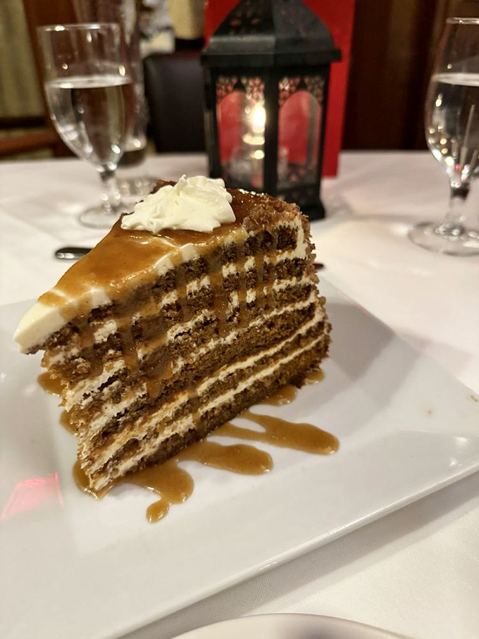 Layer upon layer of caramel-drizzled cake creating a skyscraper of sweetness that makes you wonder if architects should consider moonlighting as pastry chefs.