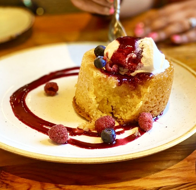 A butter cake that makes you close your eyes involuntarily, topped with berries that pretend this is somehow a balanced dessert choice.