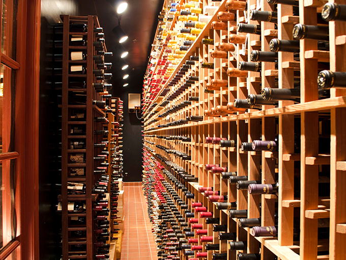 The wine cellar stretches like a library of liquid possibilities. Each bottle a story waiting to be uncorked, with some chapters costing more than others.