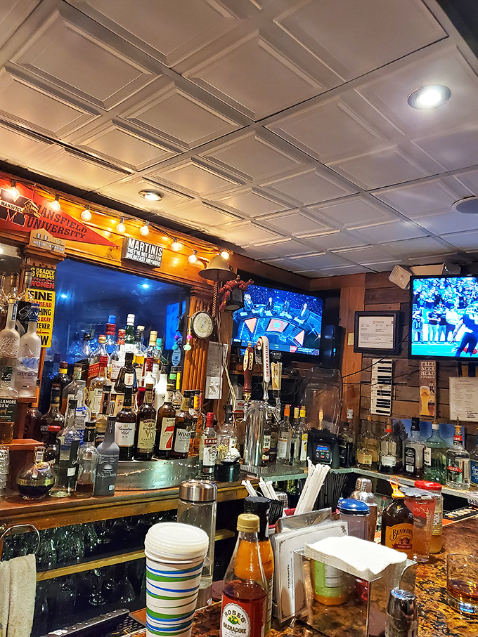 The bar gleams with promise and possibility - each bottle a story waiting to be poured, each screen offering distraction between bites.