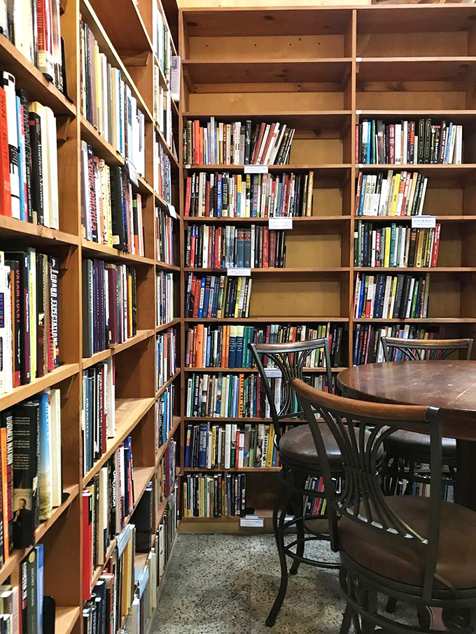 The perfect reading nook doesn't exi&mdash; Wait, it does! This corner setup with wooden shelves and bistro table practically begs for hours of reading.