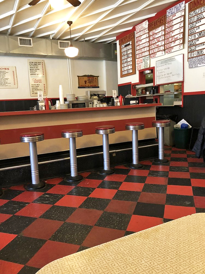 The counter at Mickie's—where solo diners find community, regulars find their usual spots, and everyone finds those red and black checkerboard floors impossibly charming.