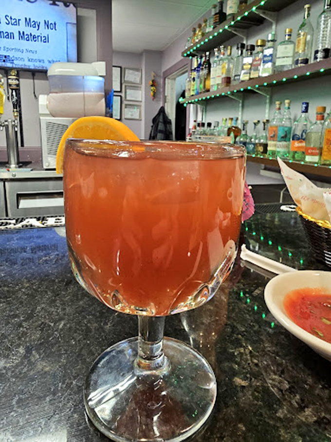 This isn't just a margarita &ndash; it's liquid sunshine in a glass, with that orange slice perched on the rim like it's enjoying the view.