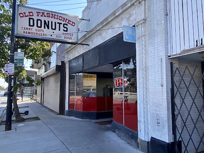 The entrance, with its distinctive red lower half, serves as a portal to a simpler time when donuts were donuts.