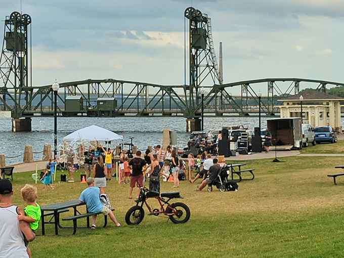 Summer evenings by the historic lift bridge transform into impromptu community celebrations where strangers become friends over shared music and sunset views.