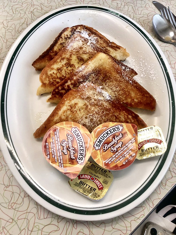 French toast dusted with powdered sugar, served with those little packets of syrup that somehow make the experience even more authentically diner-perfect.