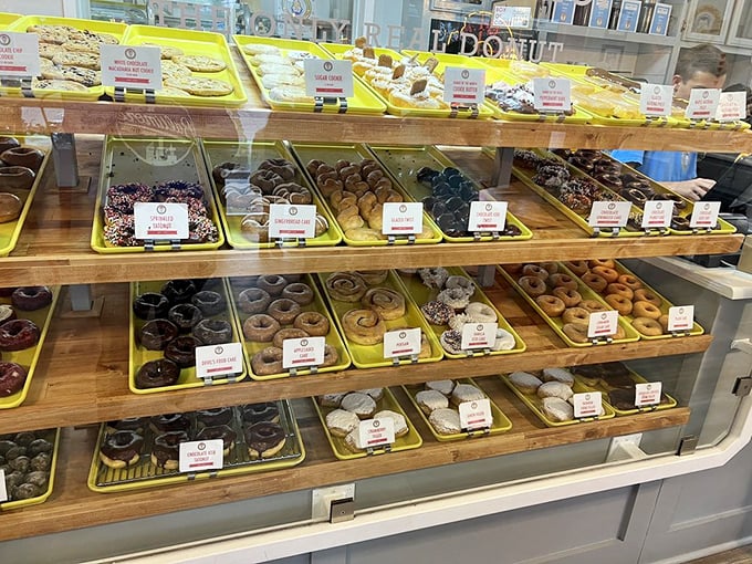 Behold the wall of temptation! Yellow trays showcase an embarrassment of riches&mdash;each shelf a different chapter in the great donut epic.