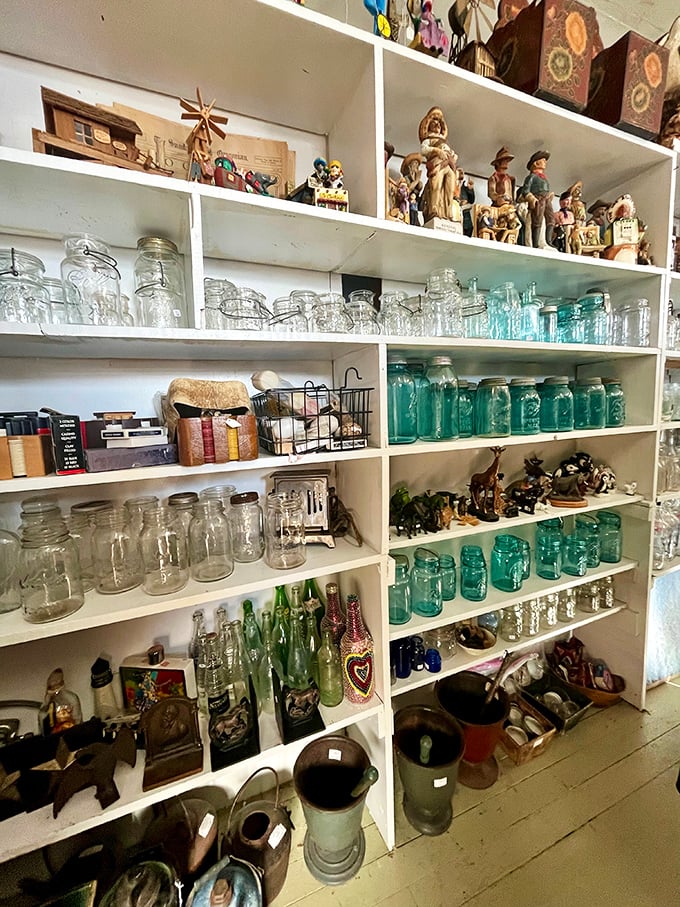 Mason jars that once preserved summer harvests now preserve history itself, lined up like soldiers from the past century's kitchen battlefields.