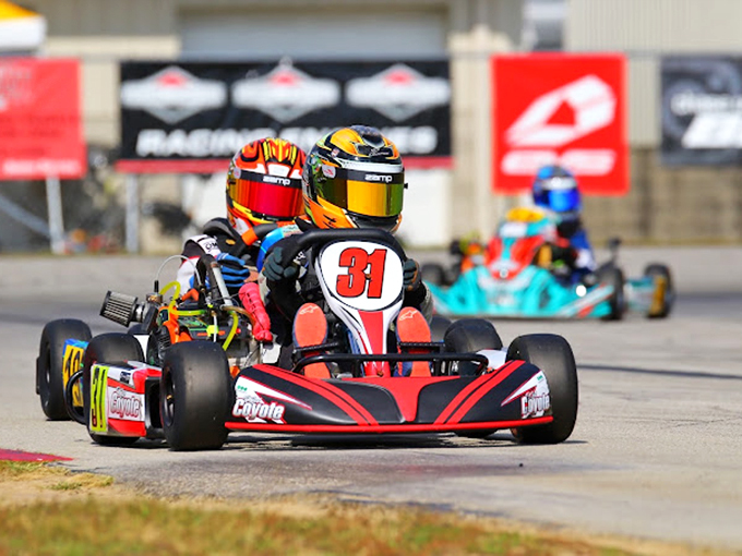 The famous Turn 3 separates the Sunday drivers from the would-be champions. That helmet's hiding either intense concentration or sheer terror.