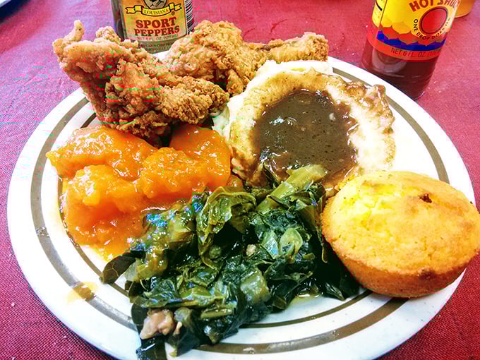 Southern hospitality served hot: fried chicken, candied yams glowing like sunset, collards with pot likker, and cornbread that demands respect.
