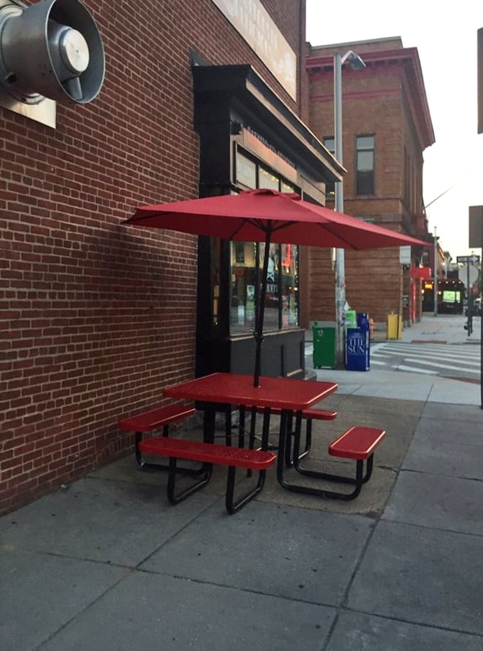 Sidewalk seating under a cherry-red umbrella. Even Baltimore's unpredictable weather can't keep dedicated pie enthusiasts away from their fix.