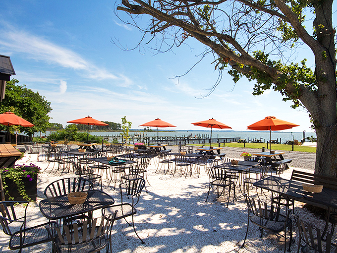 Orange umbrellas stand like cheerful sentinels guarding the waterfront dining experience. This is where memories are made, one sunset and oyster platter at a time.