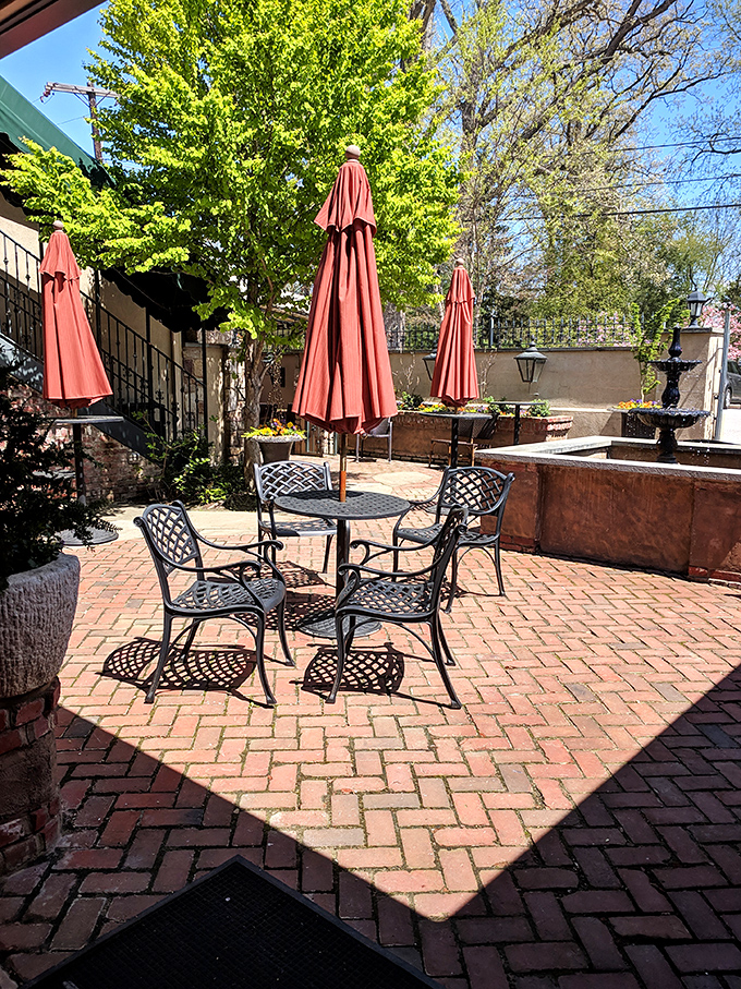 Spring sunshine bathes the patio in golden light, promising al fresco dining perfection. Those coral umbrellas stand ready to shield you from everything except overindulgence.