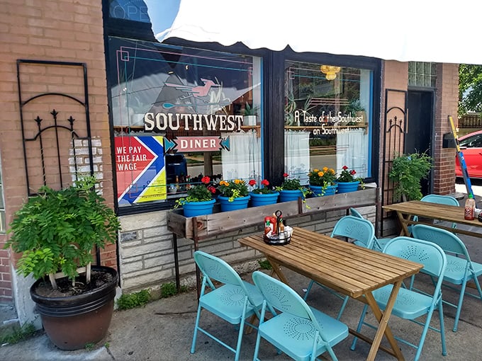 Outdoor seating that says "stay awhile" with its cheerful turquoise chairs and flower boxes. Urban dining with neighborhood charm.