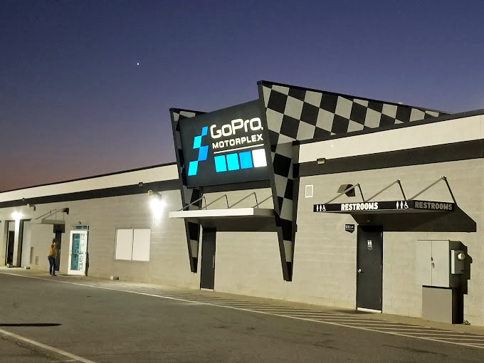 As day fades to dusk, the illuminated Trackhouse sign becomes a beacon for night owls seeking their racing fix.