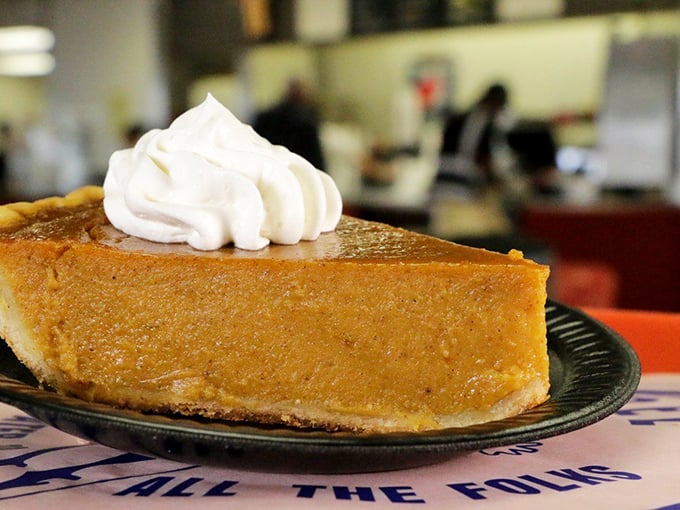 Pumpkin pie that doesn't wait for Thanksgiving to shine, topped with a cloud of whipped cream that deserves its own weather forecast.