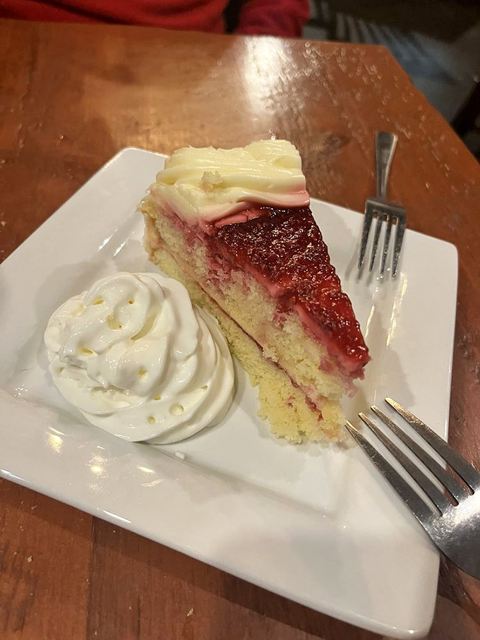 A slice of raspberry lemon cake that makes you reconsider saving room for dessert. That cream cheese frosting is the crown jewel.