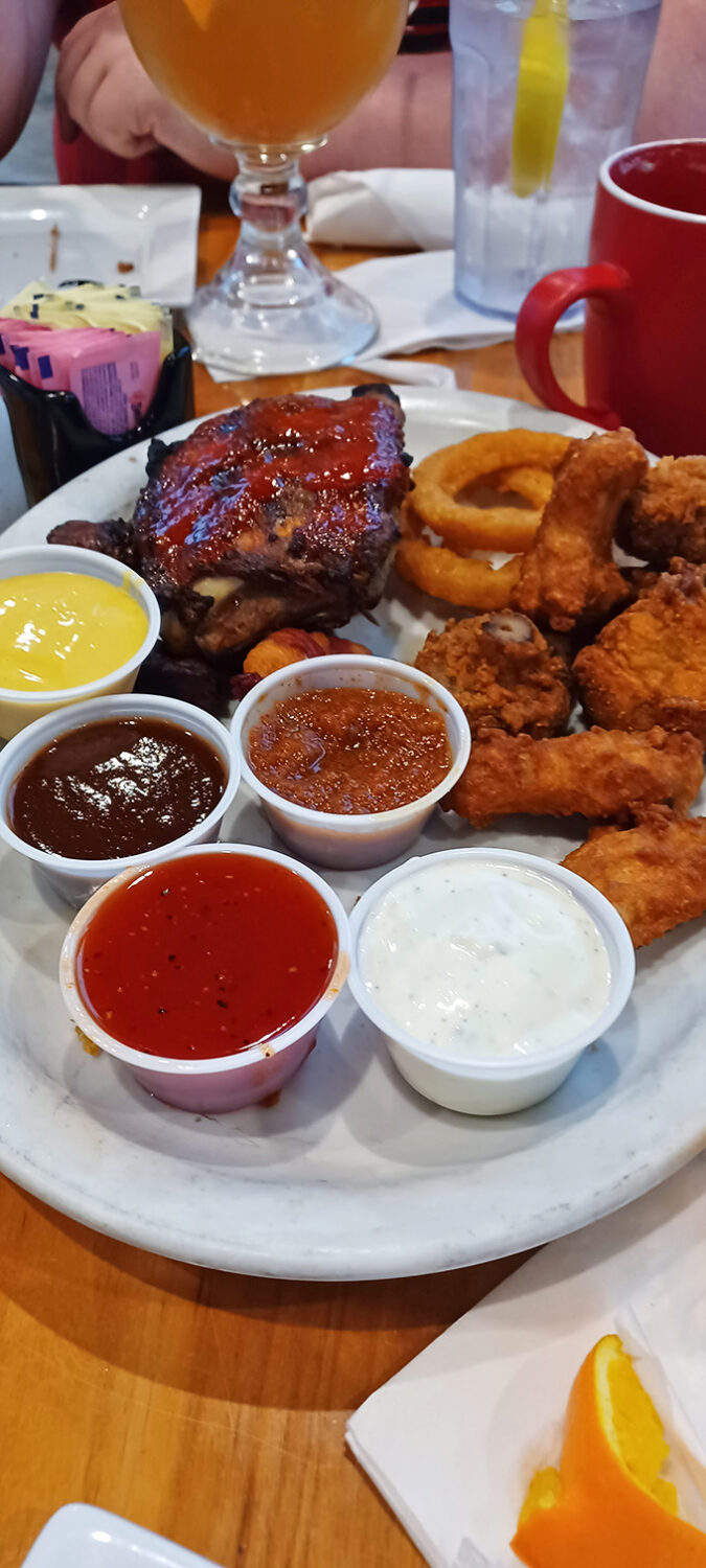 A symphony of sauces surrounding ribs and chicken tenders &ndash; proof that in the right hands, condiments aren't accessories, they're essential.