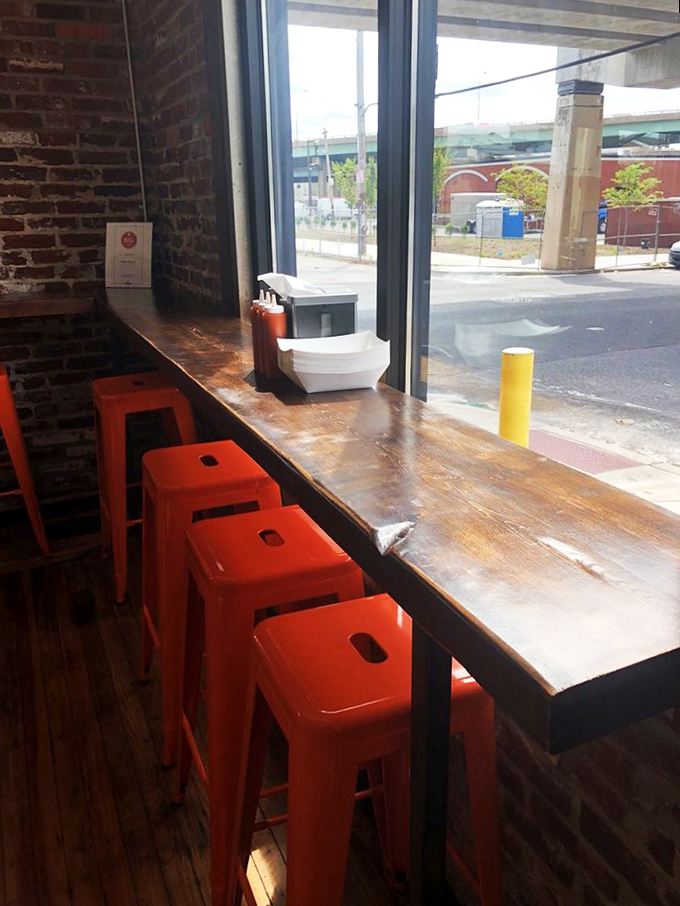 Window seating with bright orange stools—perfect for people-watching while contemplating the meaning of life and perfect fried chicken.