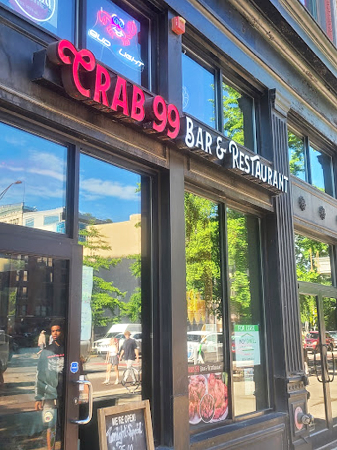 Daylight reveals Crab 99's urban habitat&mdash;a sleek storefront where the red sign serves as a beacon for downtown lunchers seeking seafood salvation.
