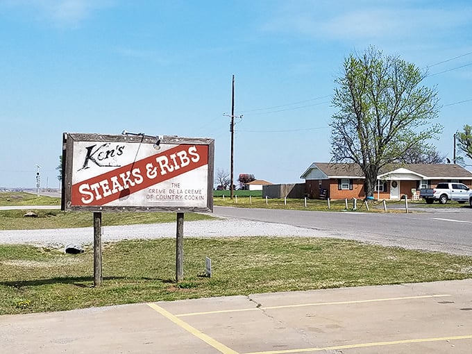 The roadside sign stands like a beacon of hope for hungry travelers, promising meaty salvation just off the highway.