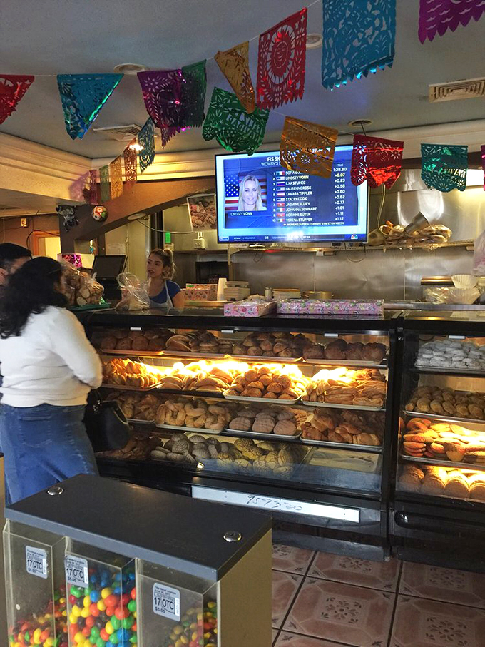 Where the magic happens&mdash;fresh pastries displayed like treasures while colorful papel picado flags create a perpetual fiesta atmosphere overhead.