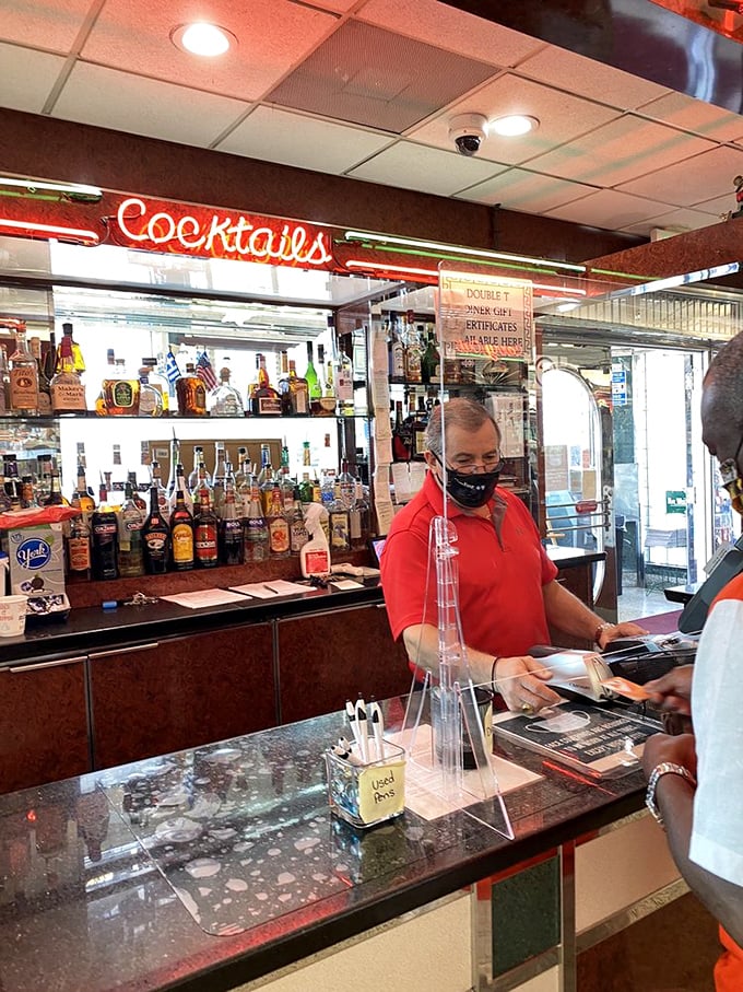 Behind that bar is where liquid magic happens. The neon "Cocktails" sign isn't just decoration&mdash;it's a promise of good times ahead.