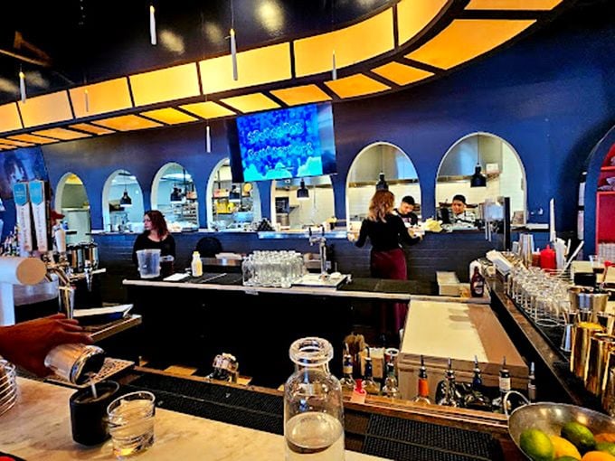 The bar area isn't just stylish&mdash;it's where the magic happens, with that distinctive curved lighting fixture hovering like a UFO of good taste.