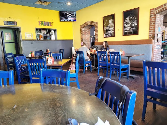 Bright blue chairs against sunny yellow walls create a cheerful canvas for morning conversations and coffee refills.