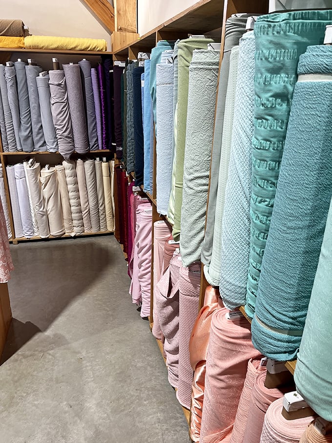 The pastel section&mdash;where fabric bolts create a soothing gradient from whites through blues to pinks, like a textile sunset.
