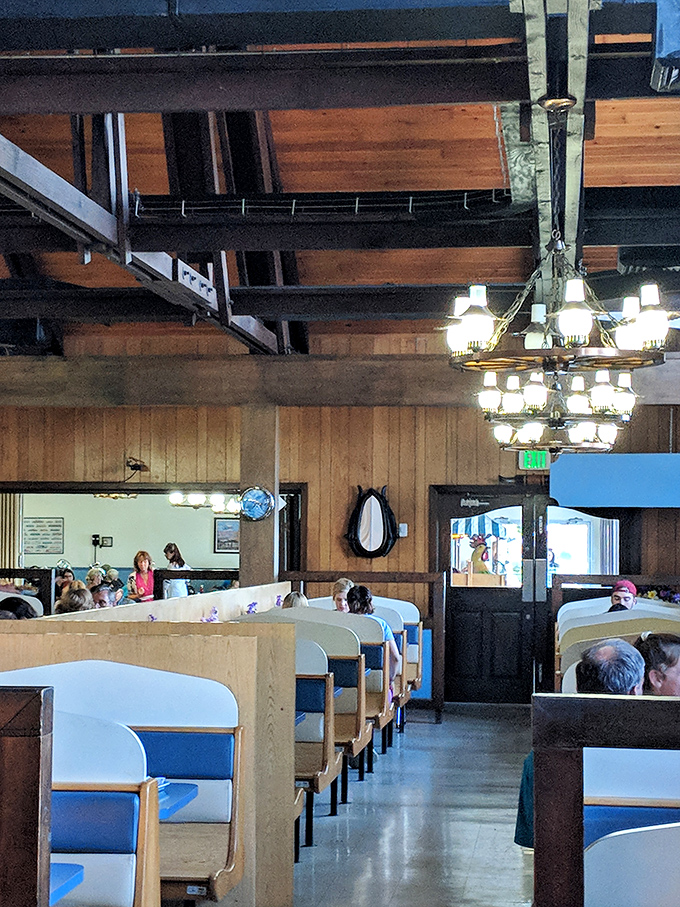 Wood paneling, booth seating, and chandeliers create that perfect "Grandpa's den meets five-star steakhouse" ambiance that keeps families coming back.