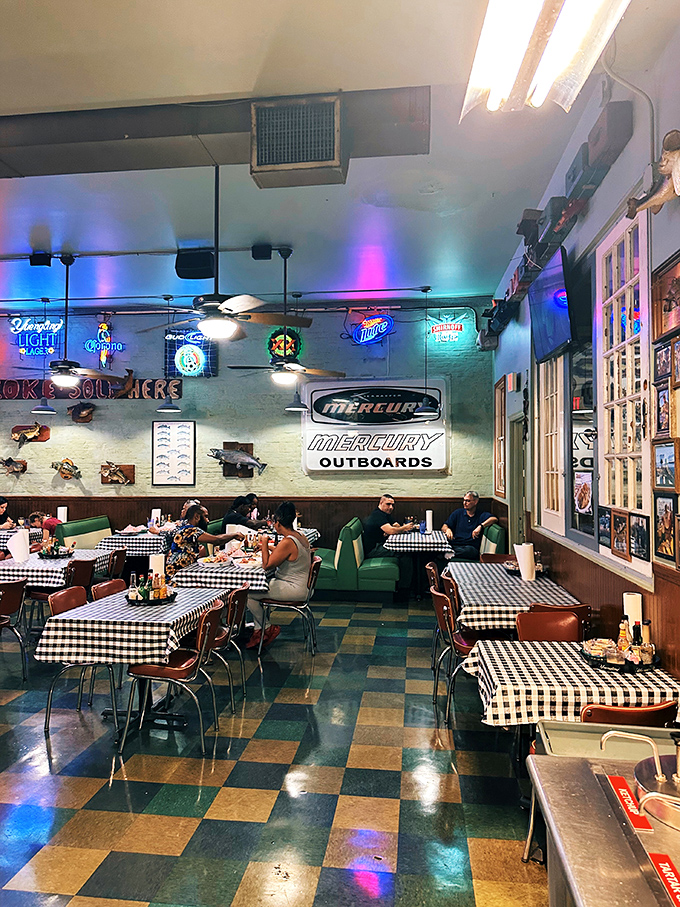 Neon signs cast a glow over happy diners. The black and white checkered tablecloths aren't just decor&mdash;they're Flying Fish tradition.