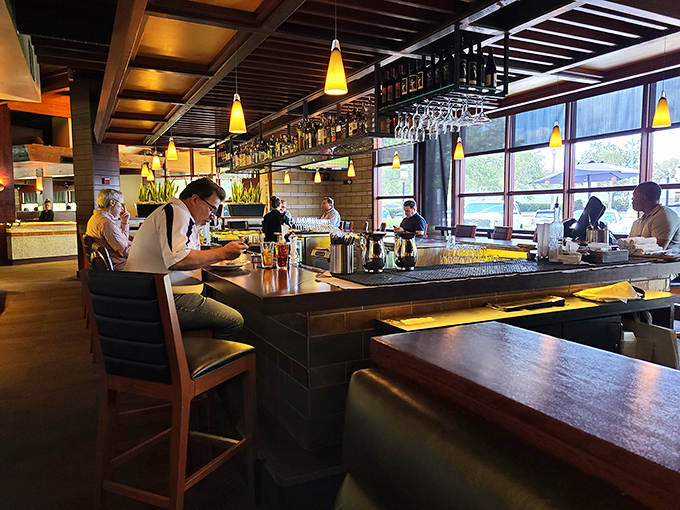 The bar area: where strangers become friends and friends become regulars. Yellow pendant lights cast a glow that makes everyone look their best.
