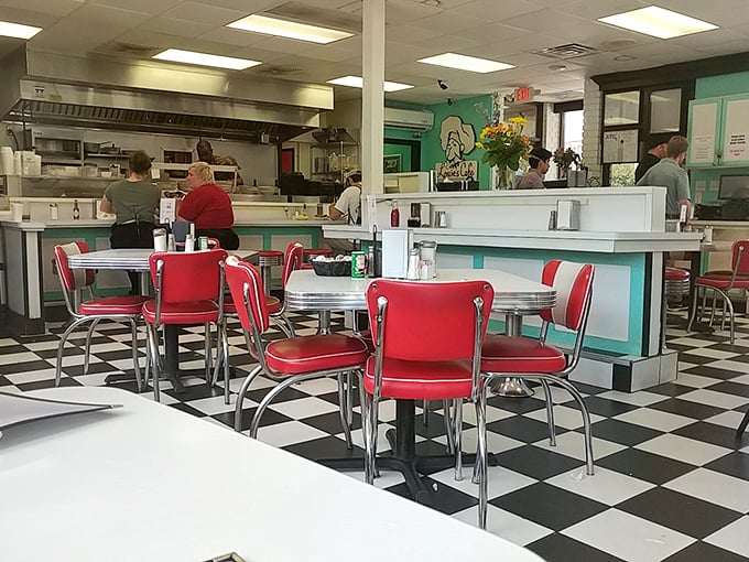 The classic diner aesthetic—red chairs against a checkerboard floor—isn't trying to be Instagram-worthy; it just accidentally is.