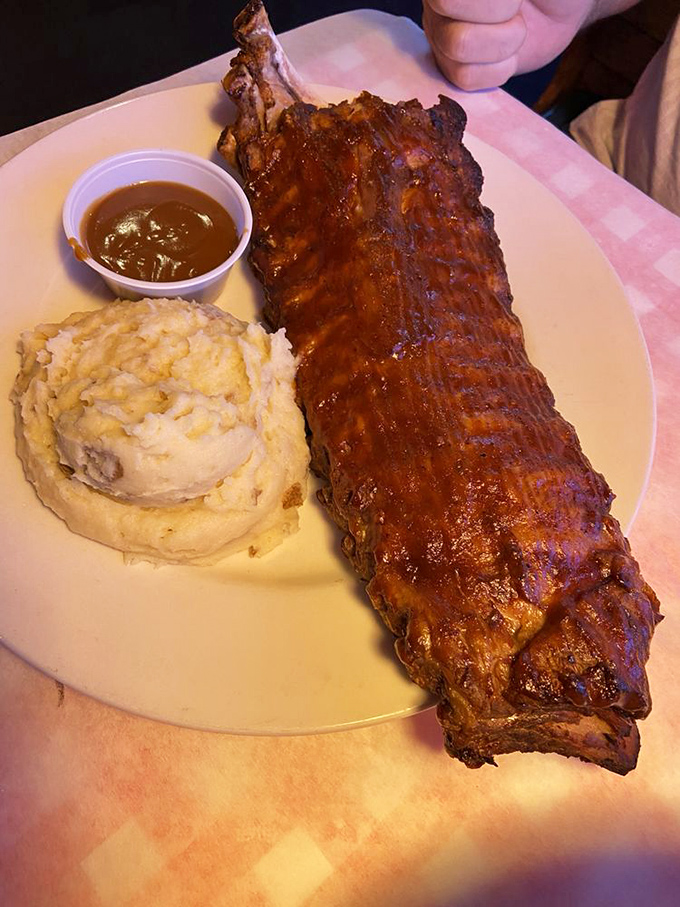 These baby back ribs aren't just falling off the bone—they're practically jumping onto your fork while the garlic mashed potatoes stand guard.
