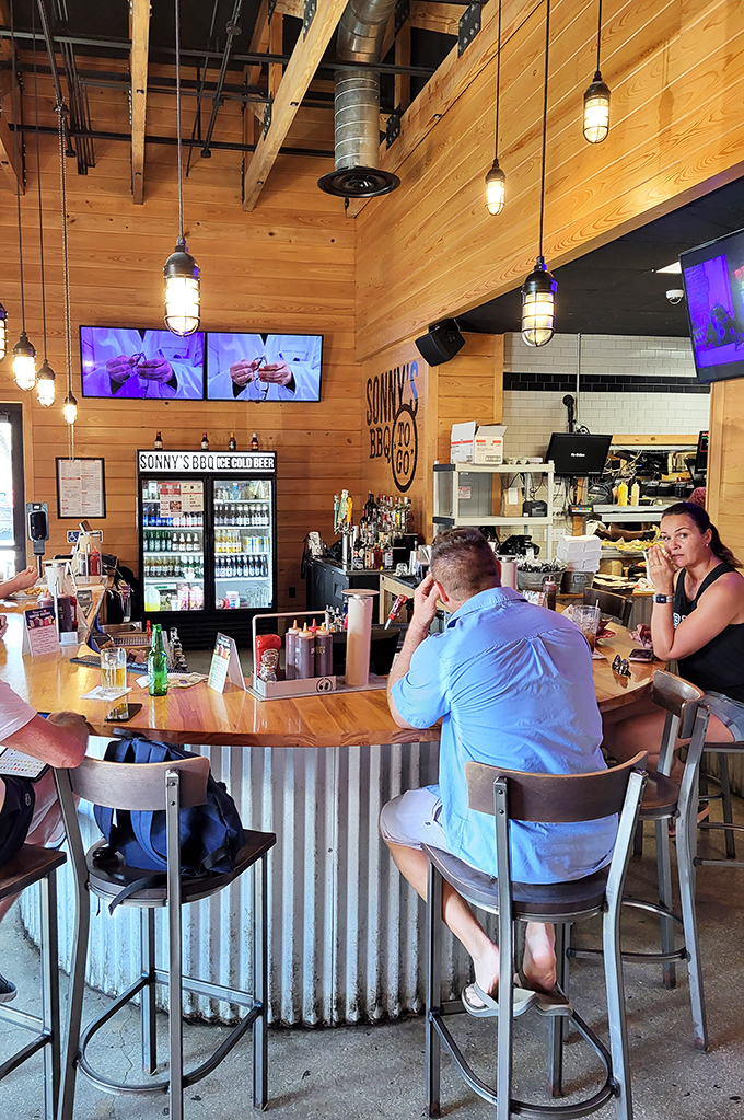 The bar area—where industrial pendant lights and wood paneling create the perfect backdrop for decisions between sweet and spicy sauce.