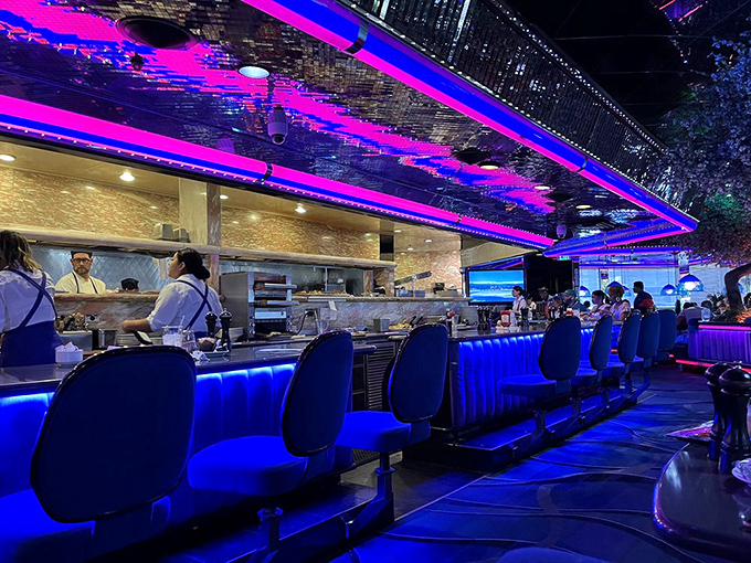 The counter seating offers front-row tickets to the culinary show. Blue neon glows like the perfect mood lighting for late-night confessions.