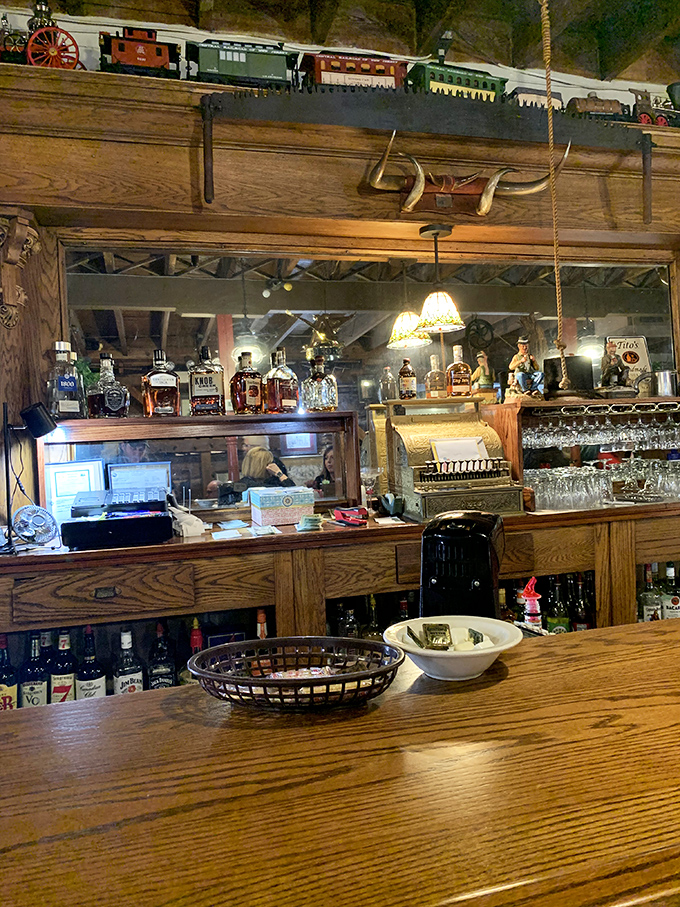 A bar where whiskey bottles stand at attention like dutiful soldiers. Note the model train above&mdash;even your drink comes with a side of nostalgia.