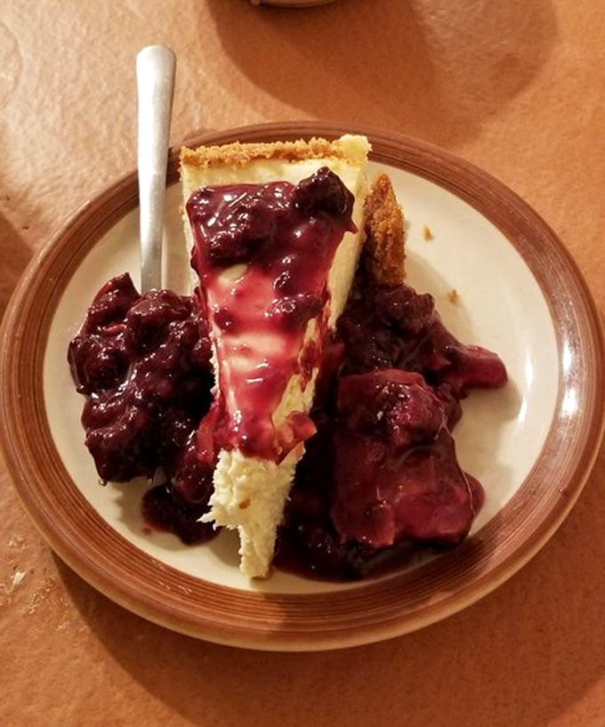 Cheesecake crowned with berry compote&mdash;proof that Monte Ne takes dessert as seriously as their legendary chicken.