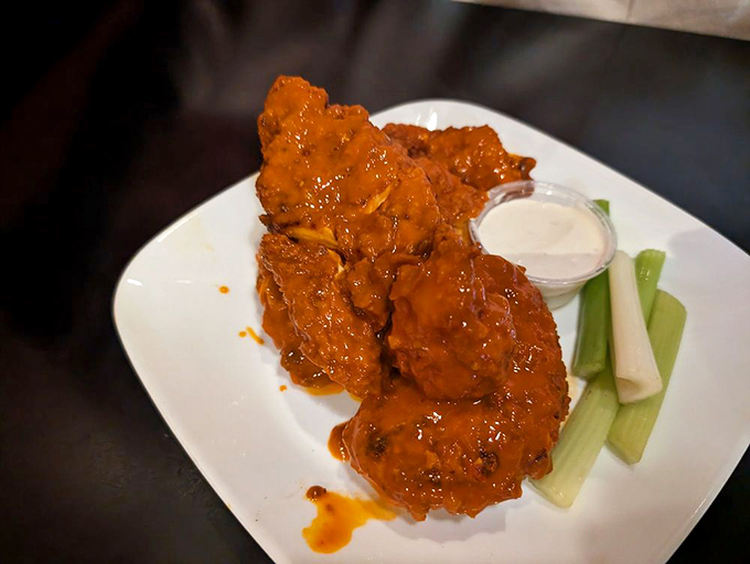 Buffalo tenders that actually look like chicken, not some processed mystery meat. The vibrant orange sauce promises a flavor punch worthy of a mosh pit.