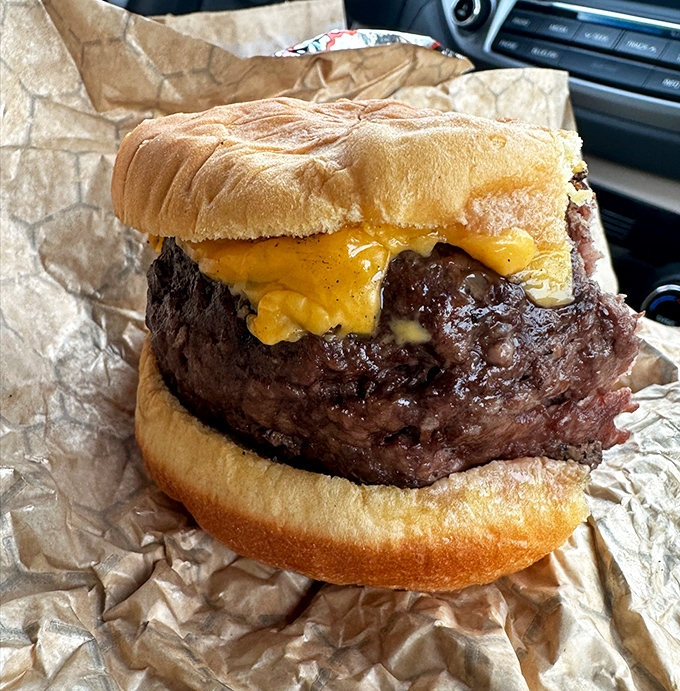 This isn't just a burger; it's a hand-formed testament to beef's higher calling, crowned with cheese that's melting into every delicious crevice.