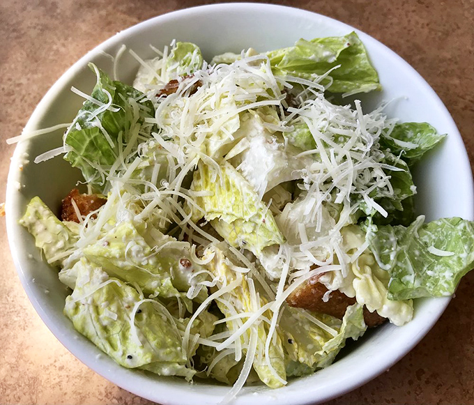 Caesar salad: the unsung hero of pizza accompaniments. Crisp romaine and shaved parmesan provide the perfect palate cleanser between slices.