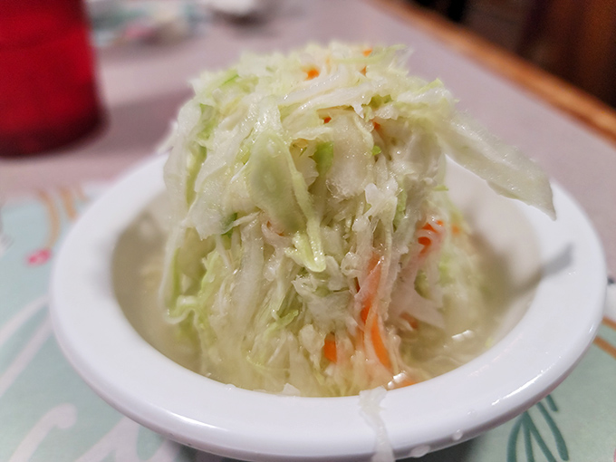 The vinegar-based coleslaw provides the perfect acidic counterpoint to rich fried chicken. Cabbage has never been so noble.