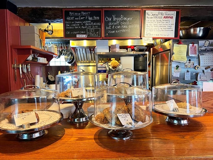 The dessert display beckons with glass-domed promises of sweet endings. Resistance is both futile and foolish.