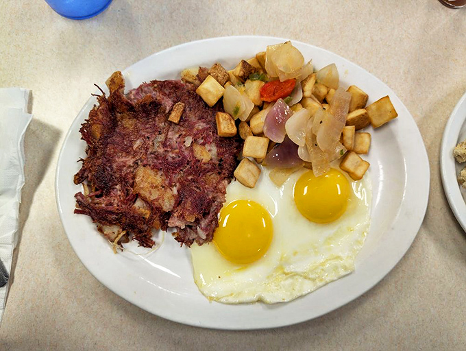 Crispy corned beef hash with sunny-side-up eggs&mdash;breakfast's dynamic duo that turns morning grumpiness into distant memory.