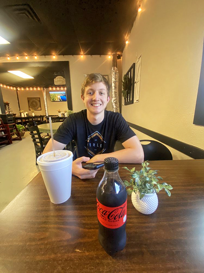 Every great meal deserves a Coca-Cola companion. The tiny plant centerpiece pretends this is fancy dining, but the food knows better.